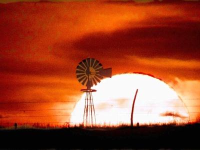 'A Blazing Sun Drops Behind a Windmill' Photographic Print | AllPosters.com