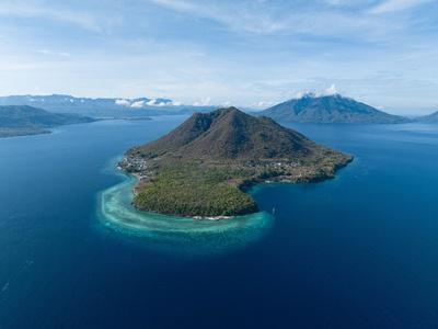 A fringing reef grows along the edge of a remote, volcanic island near ...