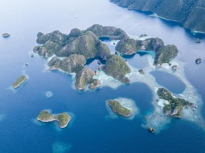 Beautiful limestone islands rise from the calm seas of Raja Ampat ...