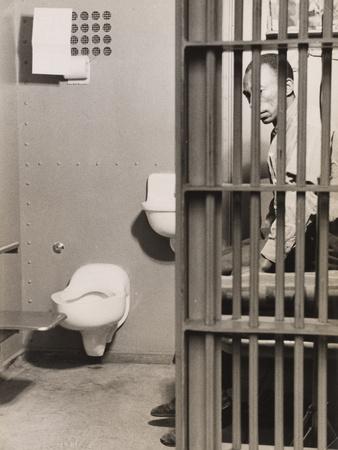 'Inmate sitting on bed with open cell door' Photographic Print - Lucien ...