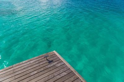'Jetty to a tropical beach. Edge of the water, jetty and the blue ...