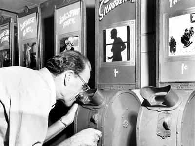 'Man Looking into a Nickelodeon Film Machine' Photo | AllPosters.com