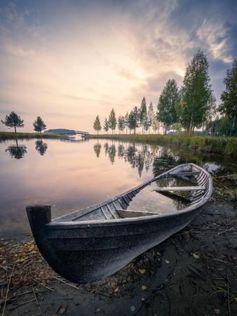 'Old rowboat with calm lake and mood sunset at autumn evening in ...
