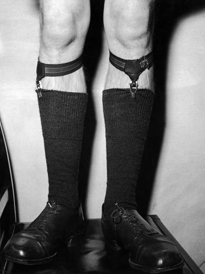A Man Using "Sock Suspenders" to Hold Up His Socks; in America They are ...