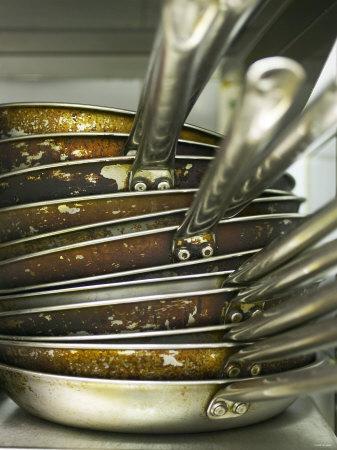 A Pile of Frying Pans in a Commercial Kitchen Photographic Print by ...
